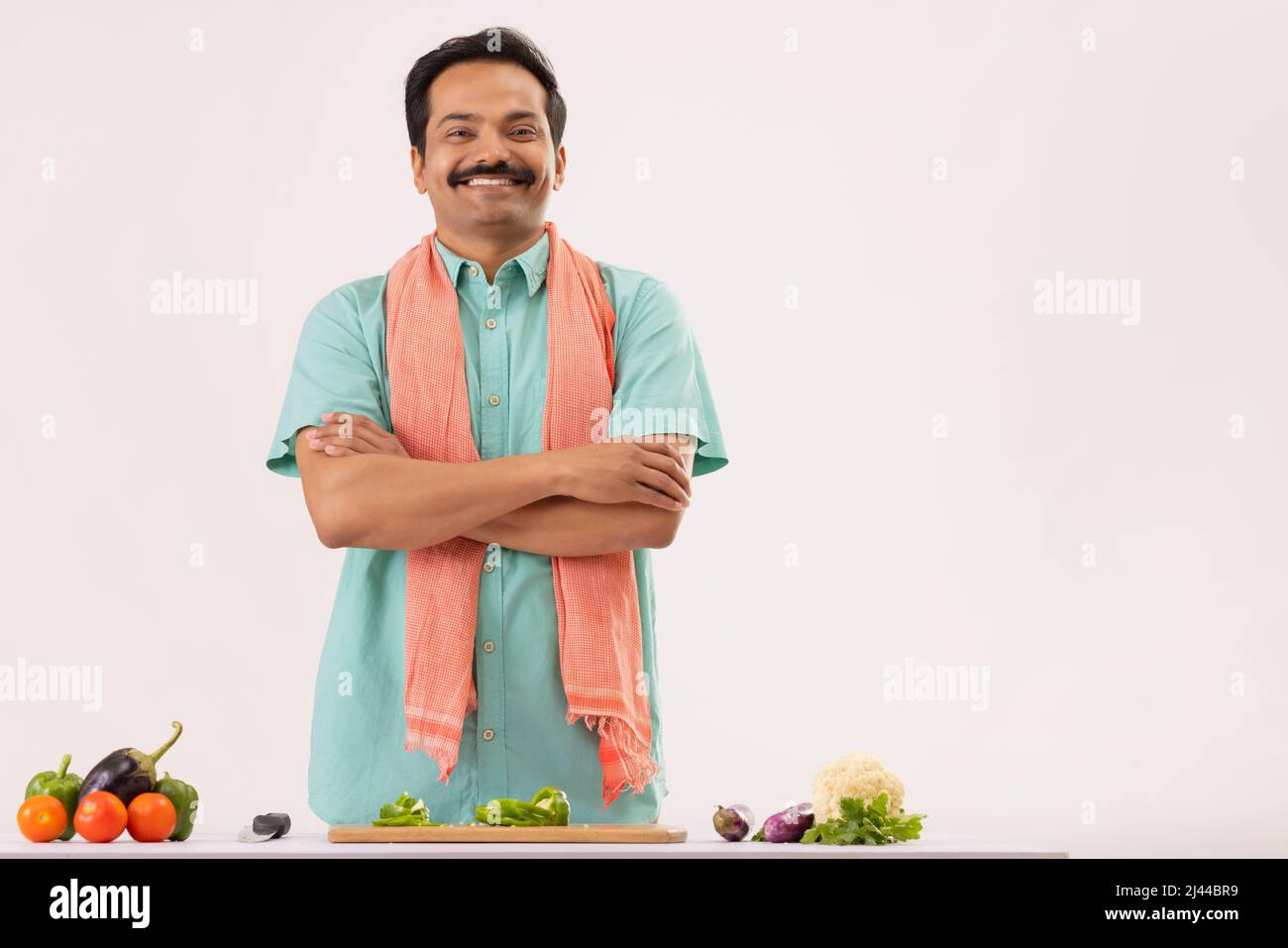 Portrait of cook servant posing with arms folded in kitchen Stock Photo ...