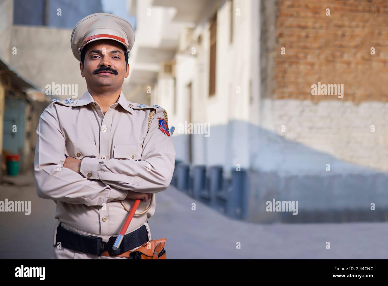 Portrait of an Indian policeman standing with arms folded Stock Photo ...