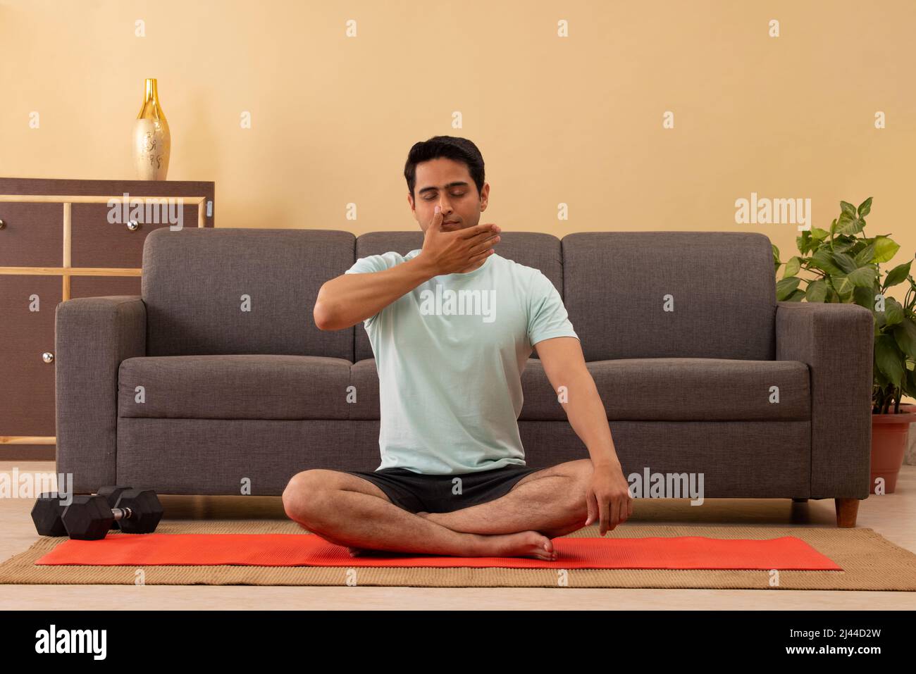 Portrait of a young man doing breathing exercise at home Stock Photo ...