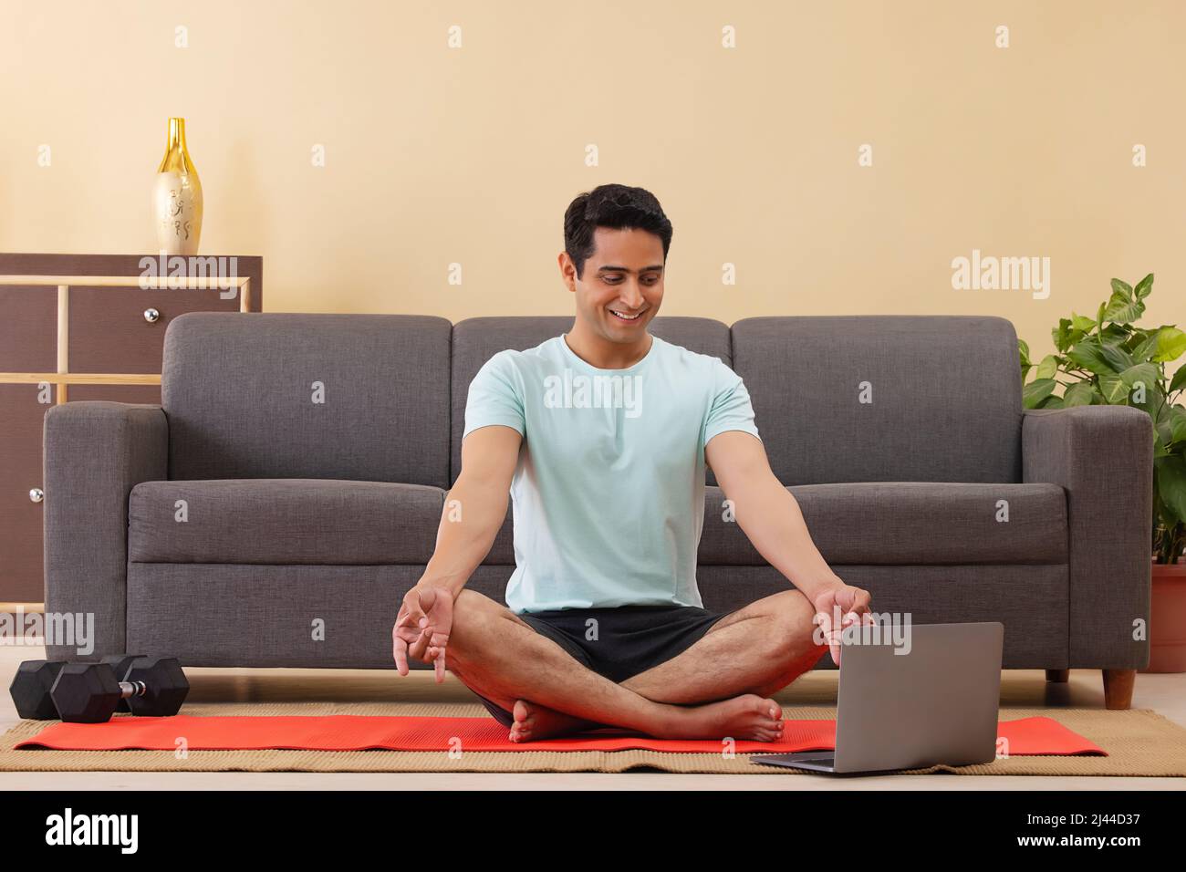 Male Indian Yoga instructor conducting an online class with laptop ...