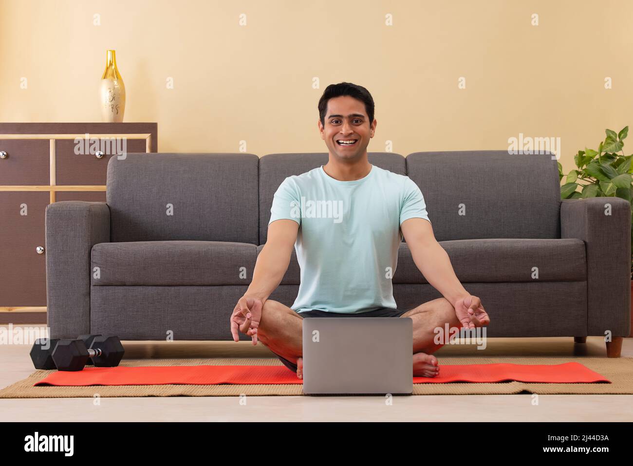 Male Indian Yoga instructor conducting an online class with laptop ...