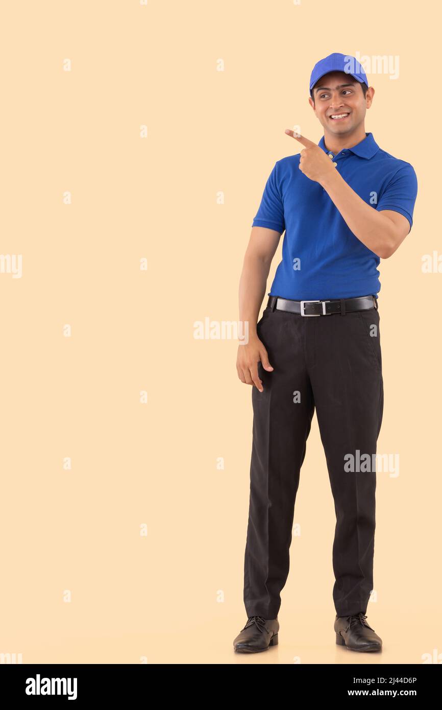 Portrait of a courier delivery boy pointing elsewhere with finger Stock ...