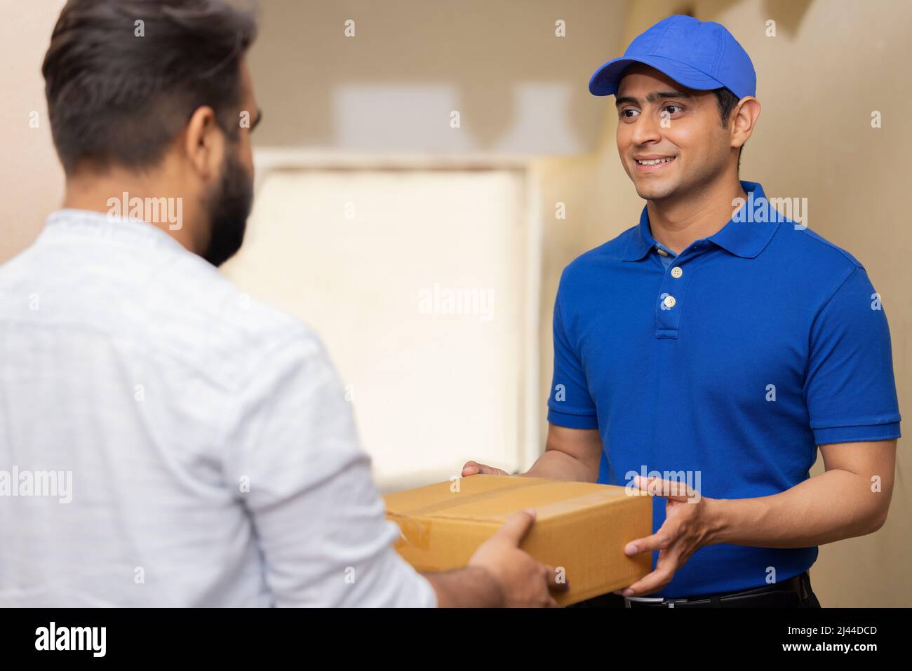 Portrait of a courier delivery boy delivering parcel to customer Stock ...