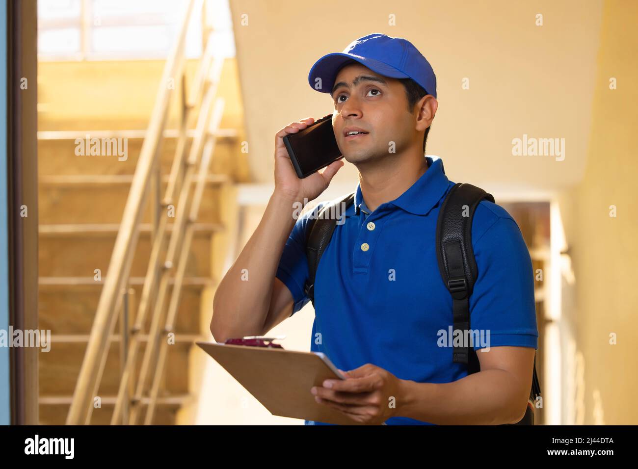 Portrait of courier delivery boy talking on Smartphone Stock Photo - Alamy