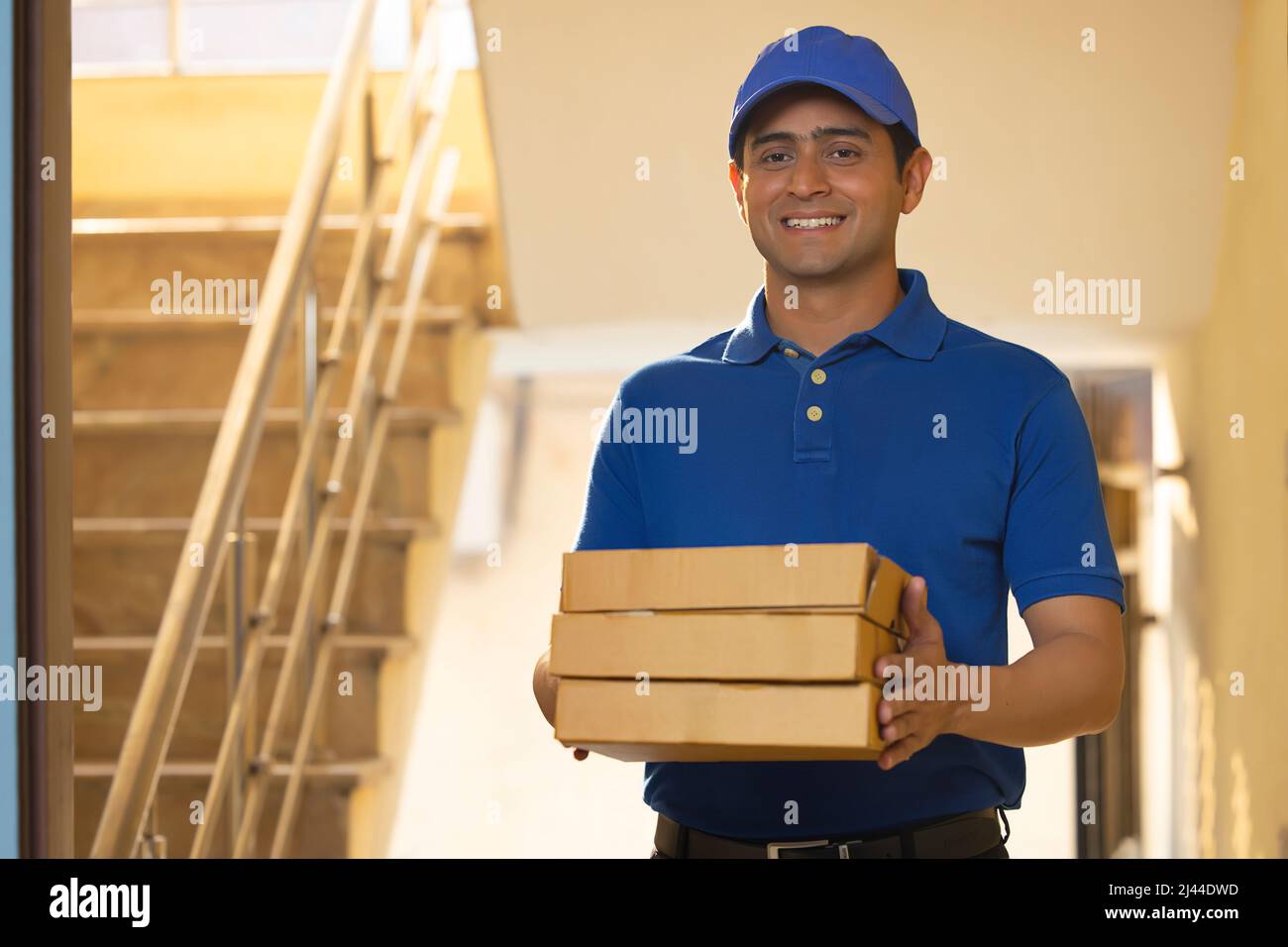 Portrait of courier delivery boy with parcels in his hand Stock Photo ...