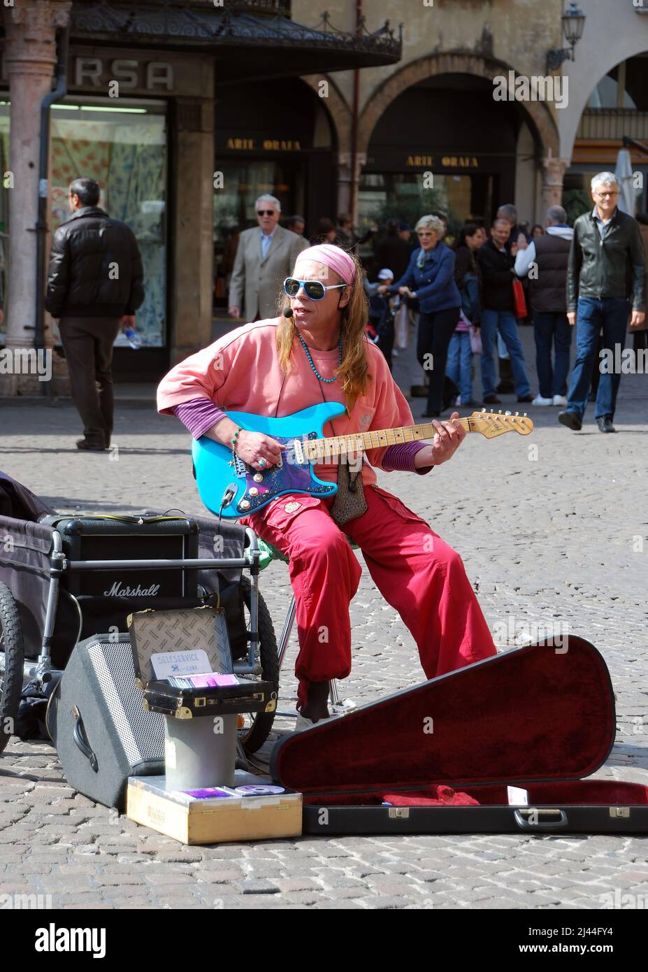 Street performer playing rock music with an electric guitar in the ...