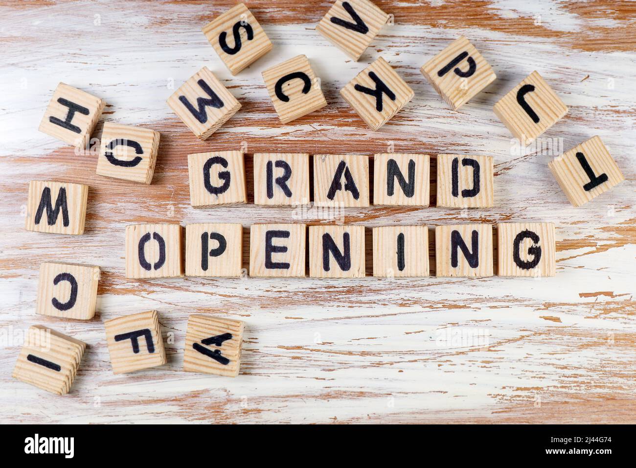 Grand Opening. Text and alphabet blocks on a wooden texture background ...