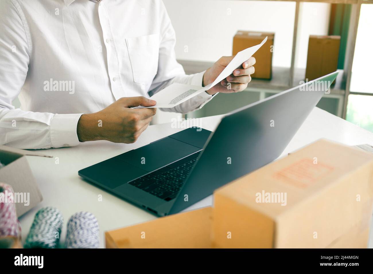 Asian man is holding a piece of paper to check the list of customer ...