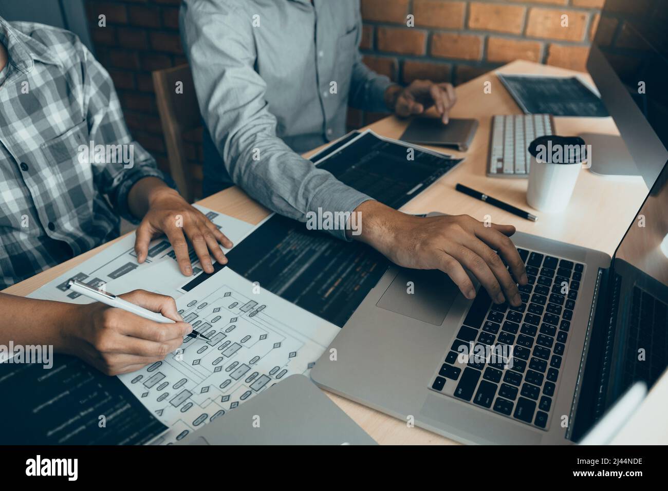 Two software developers are using computers to work together with their ...