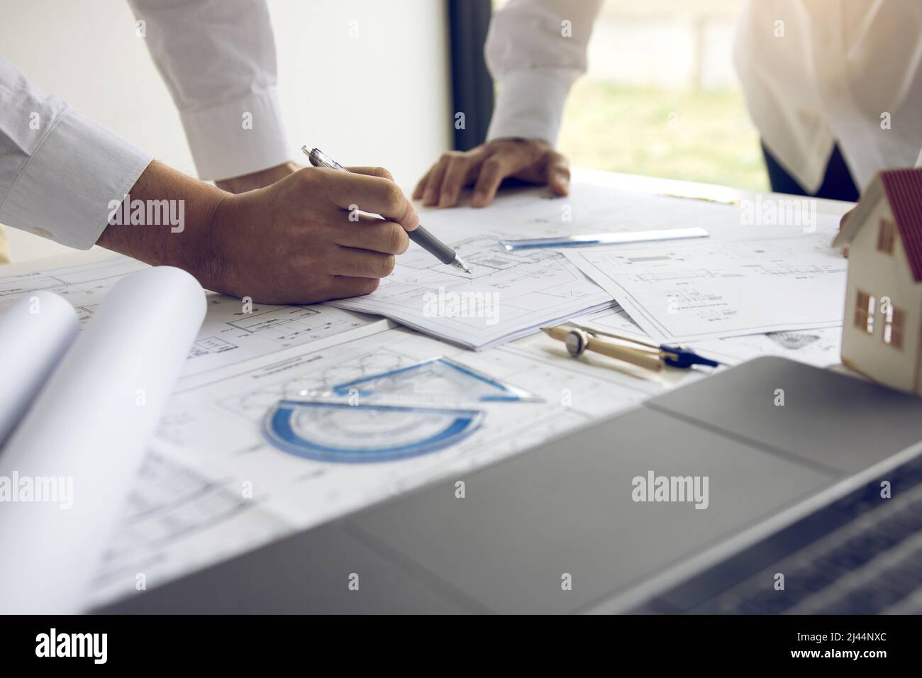 Engineering man showing blueprint detail for people buying house Stock ...