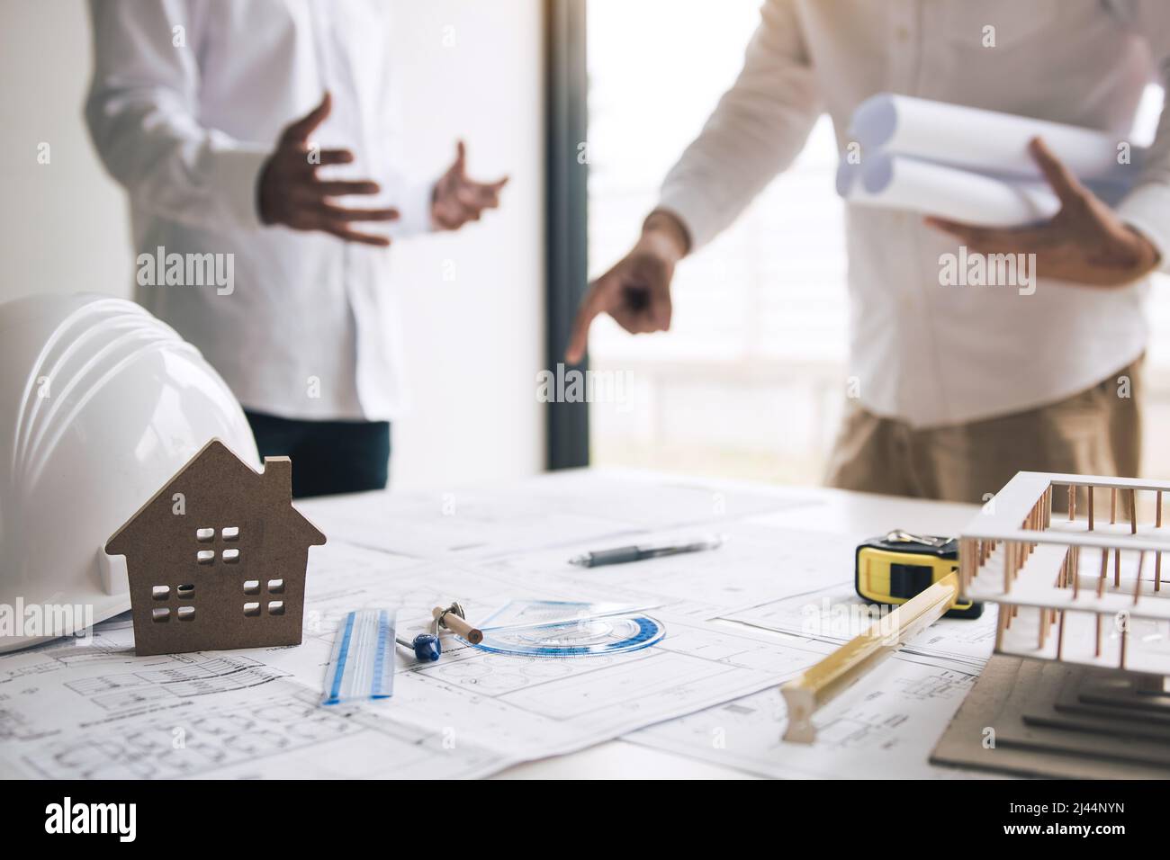 Two engineering man standing examining working discussion on blueprint ...
