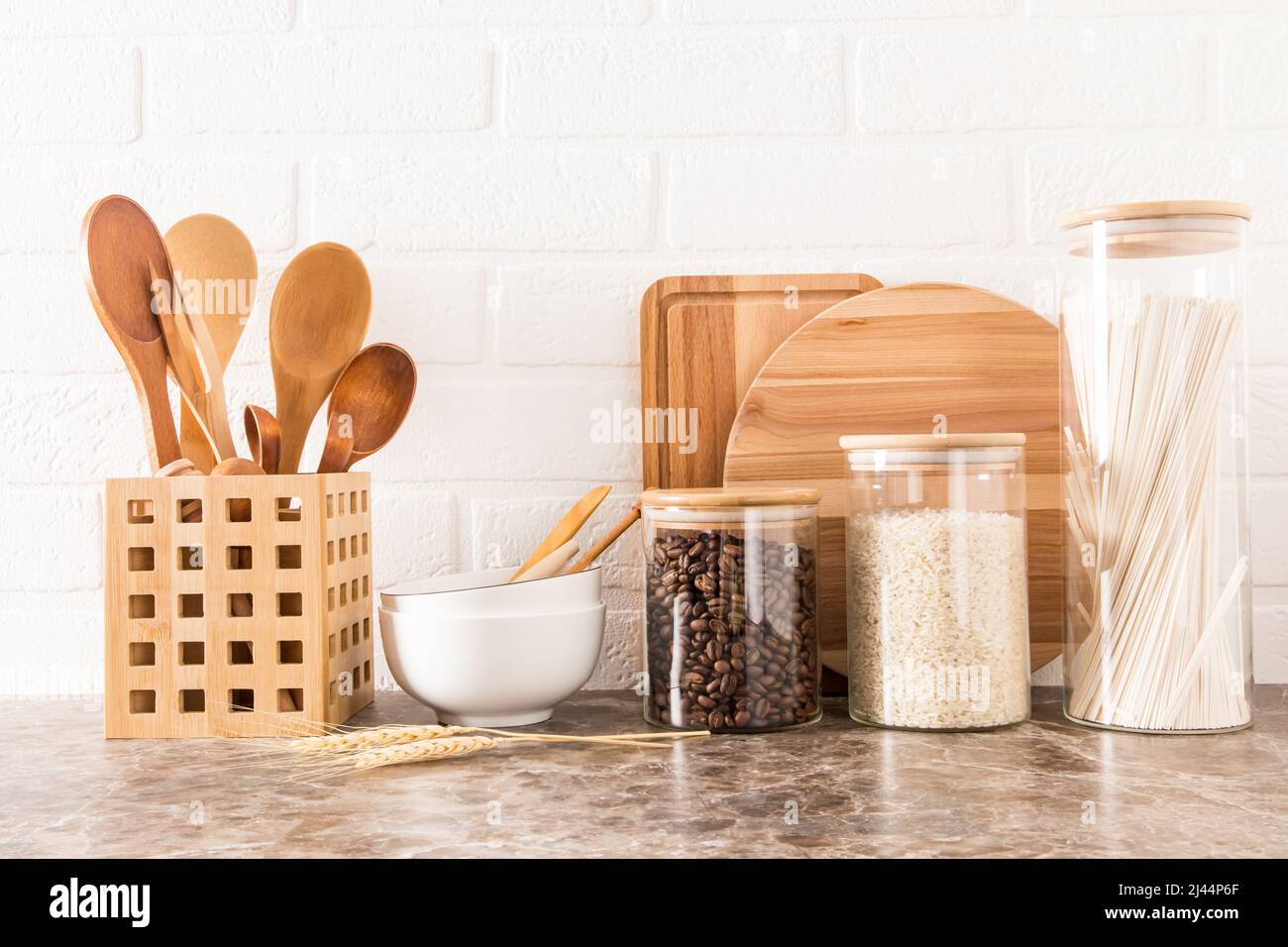 a set of kitchen utensils on a dark marble countertop against a white ...