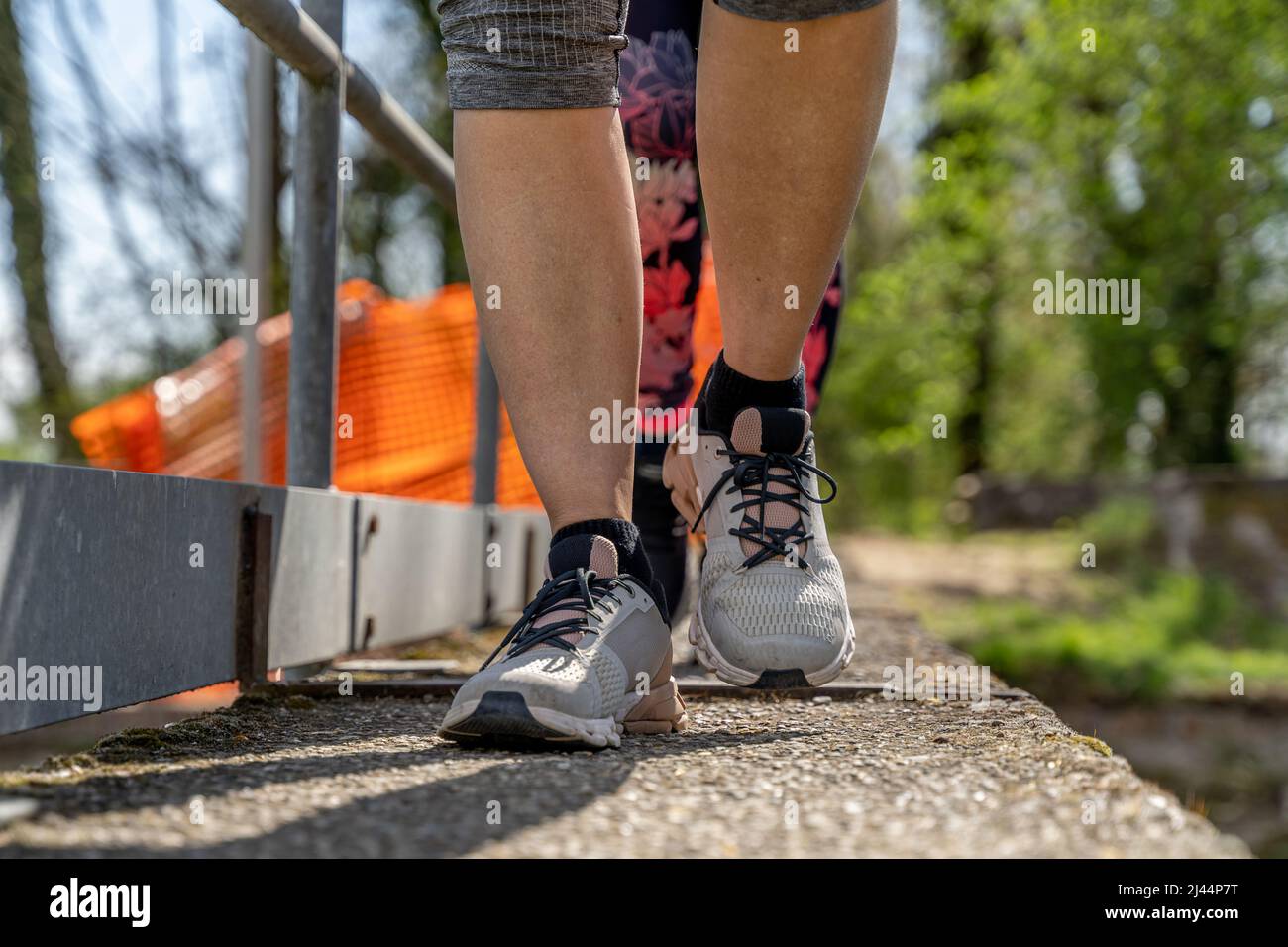 women running on a concrete bridge wearing sportswear - healthy ...