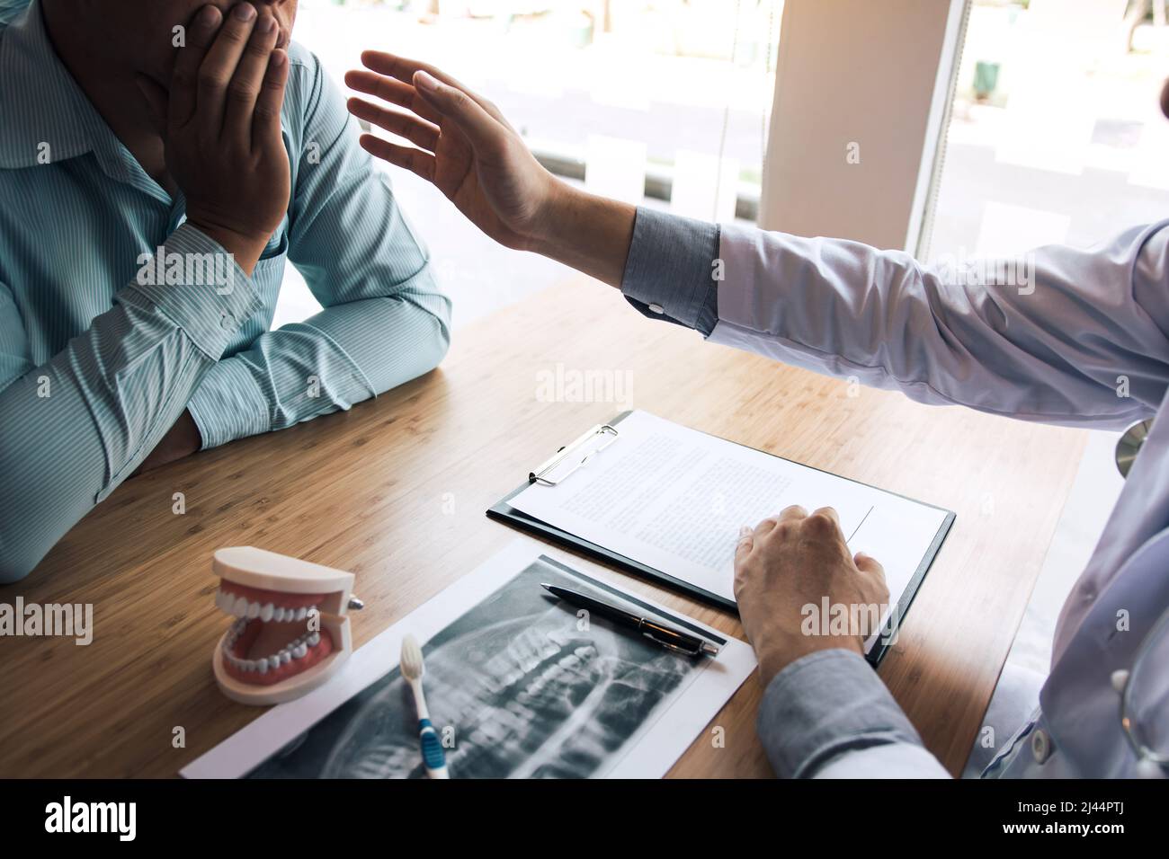 Dentist hand holding pen pointing x-ray picture and talking to the ...