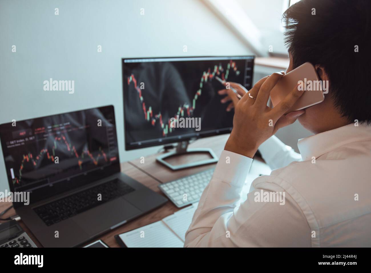 Agent trader man talking at telephone and checking business stock data ...