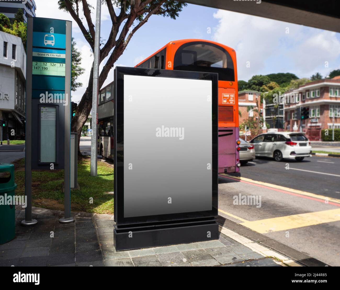 Blank billboard mock up at a bus stop with busy traffic in Singapore ...