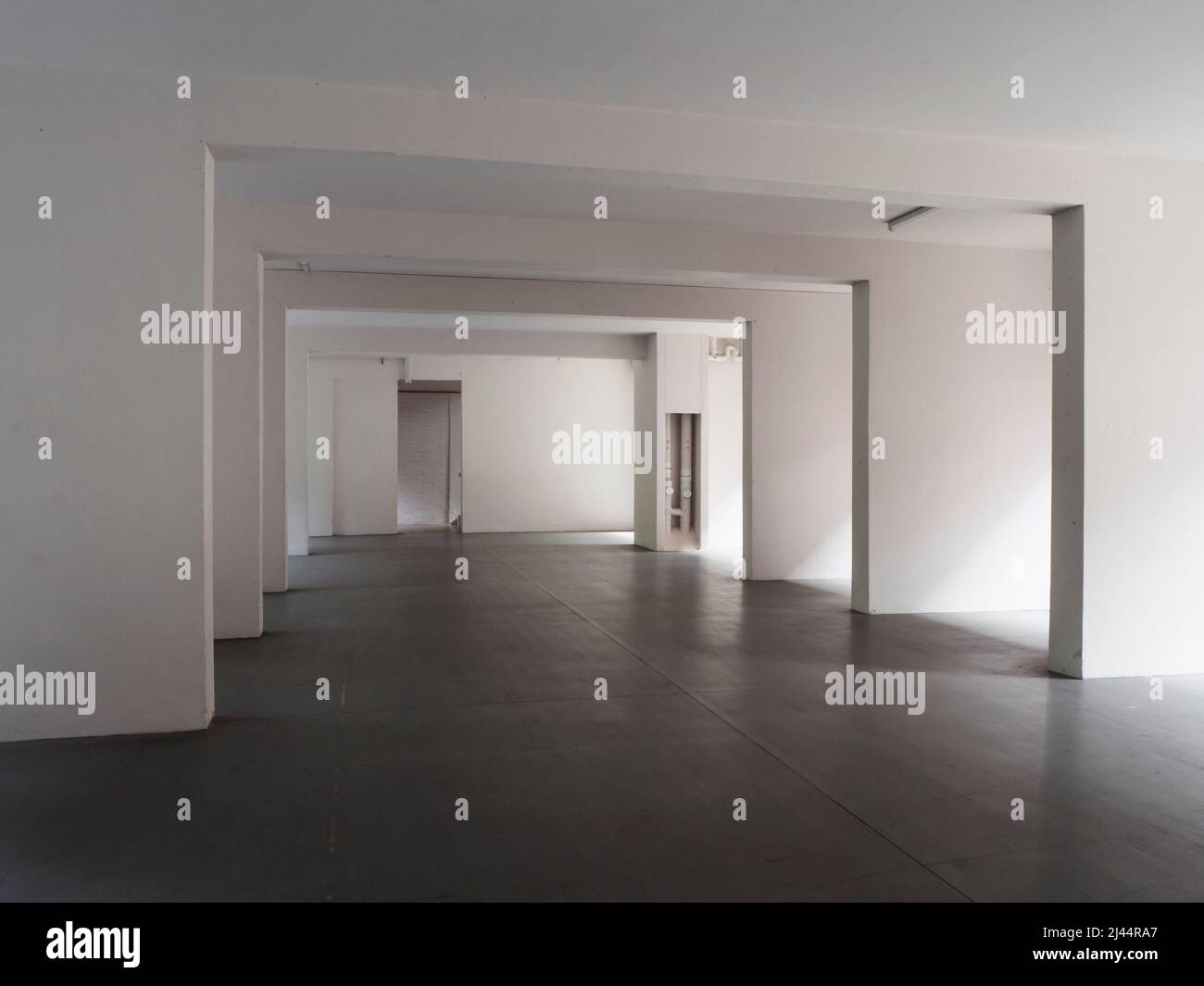 Abstract, empty void deck of an apartment block with sunlight streaming ...