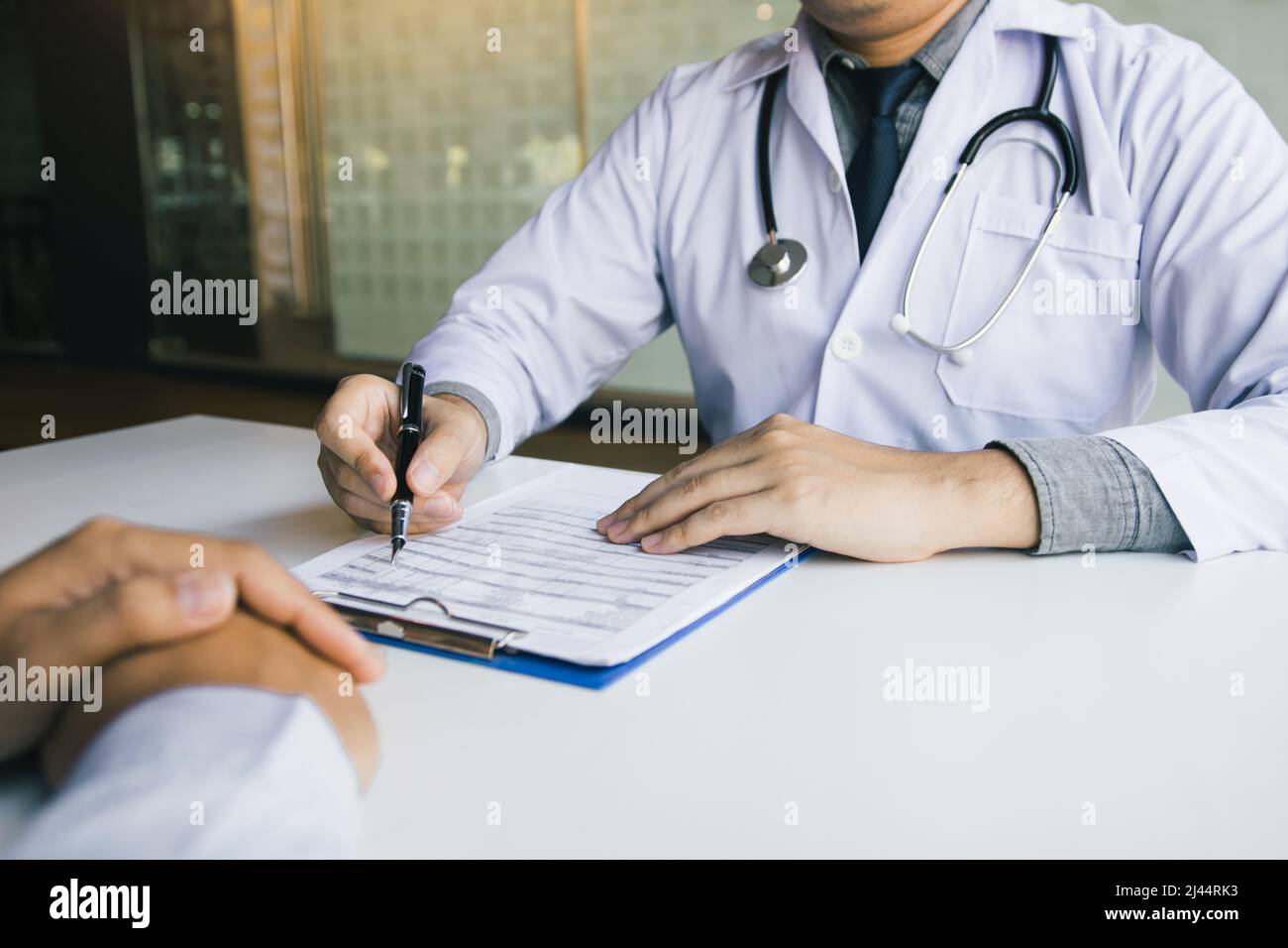 Doctor hand holding pen and talking to the patient about medication and ...