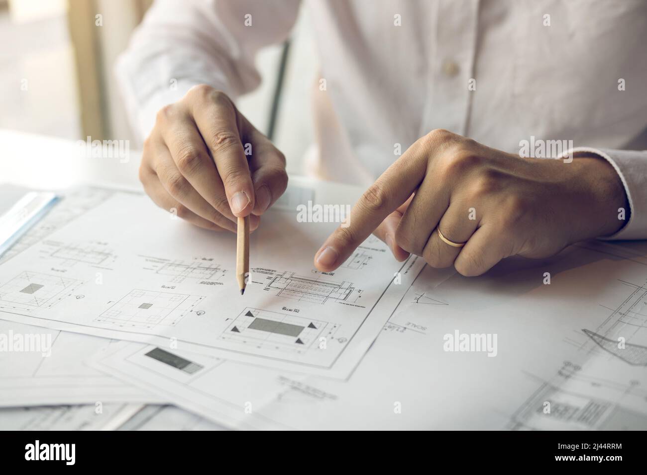 Engineering man showing blueprint detail for people buying house Stock ...
