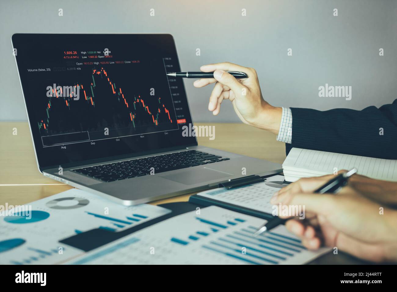 Two investors working together are analyzing the stock chart on the ...