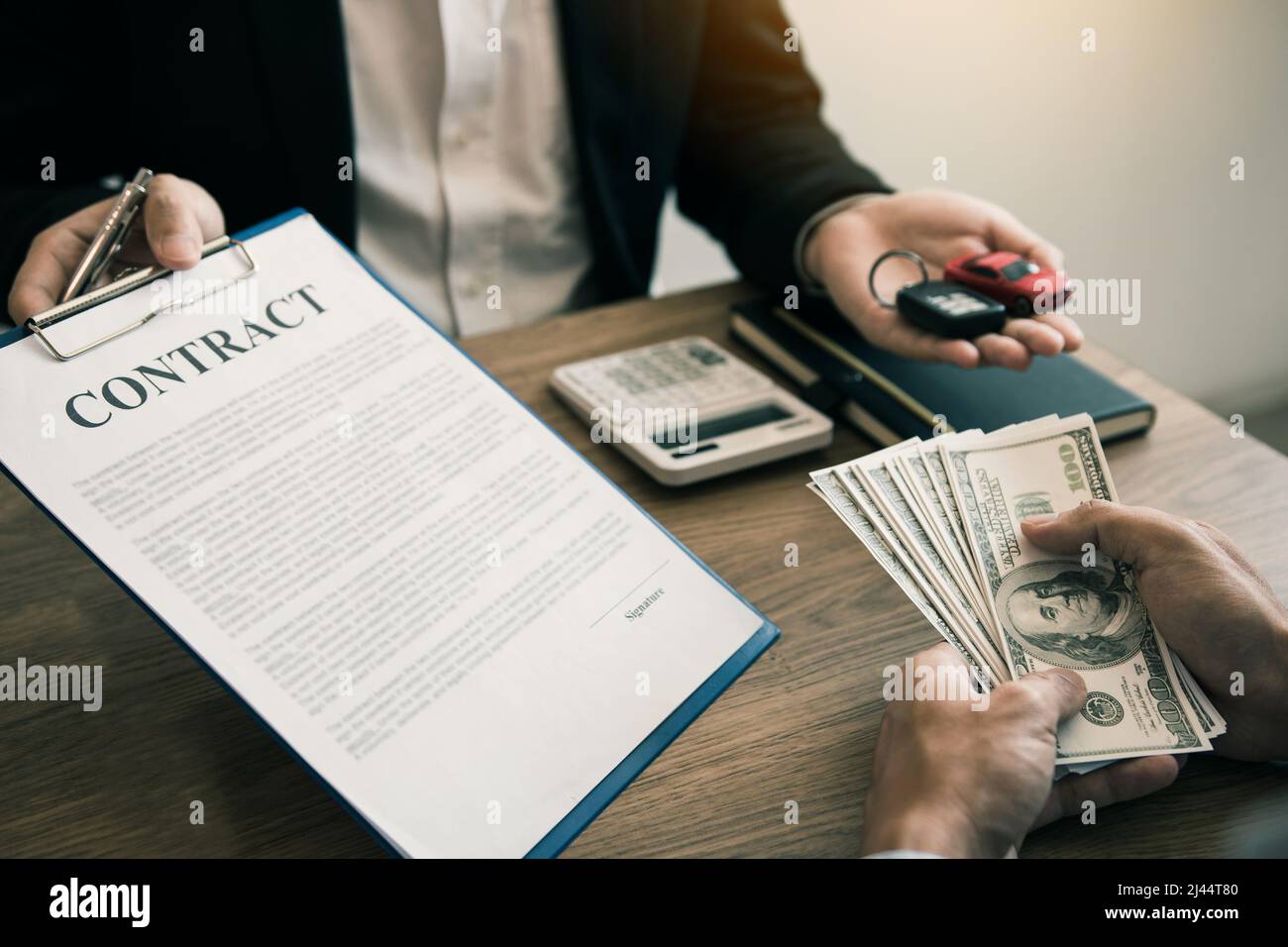 New car buyers are holding cash and handing it to car salespeople while ...