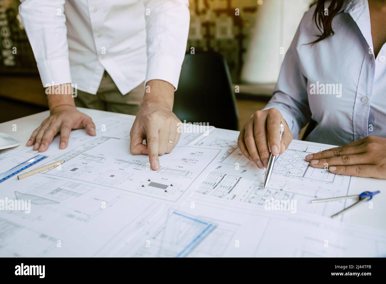 Engineering man showing blueprint detail for people buying house Stock ...
