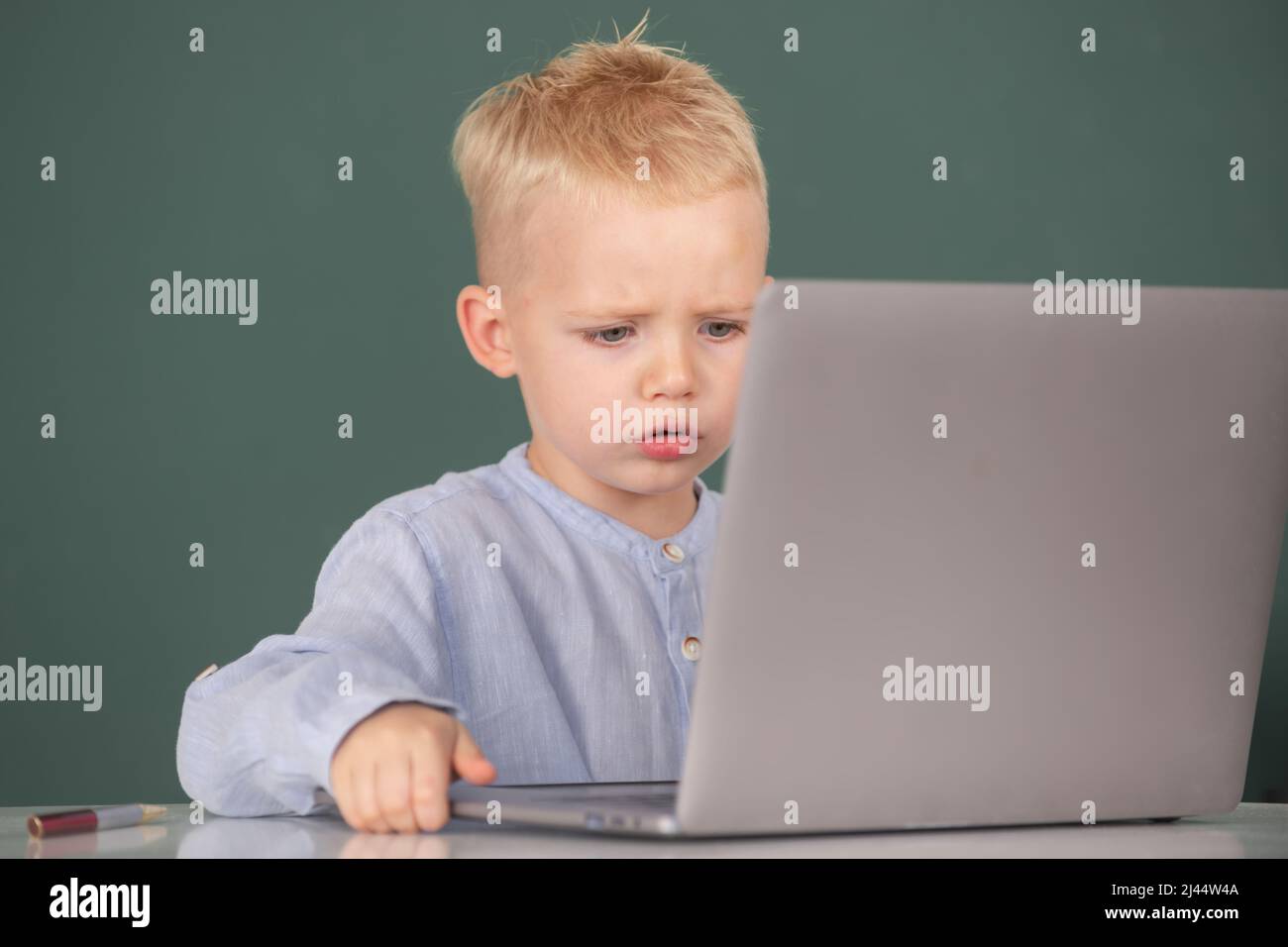 Serious concentrate child using laptop computer, kid boy studying ...