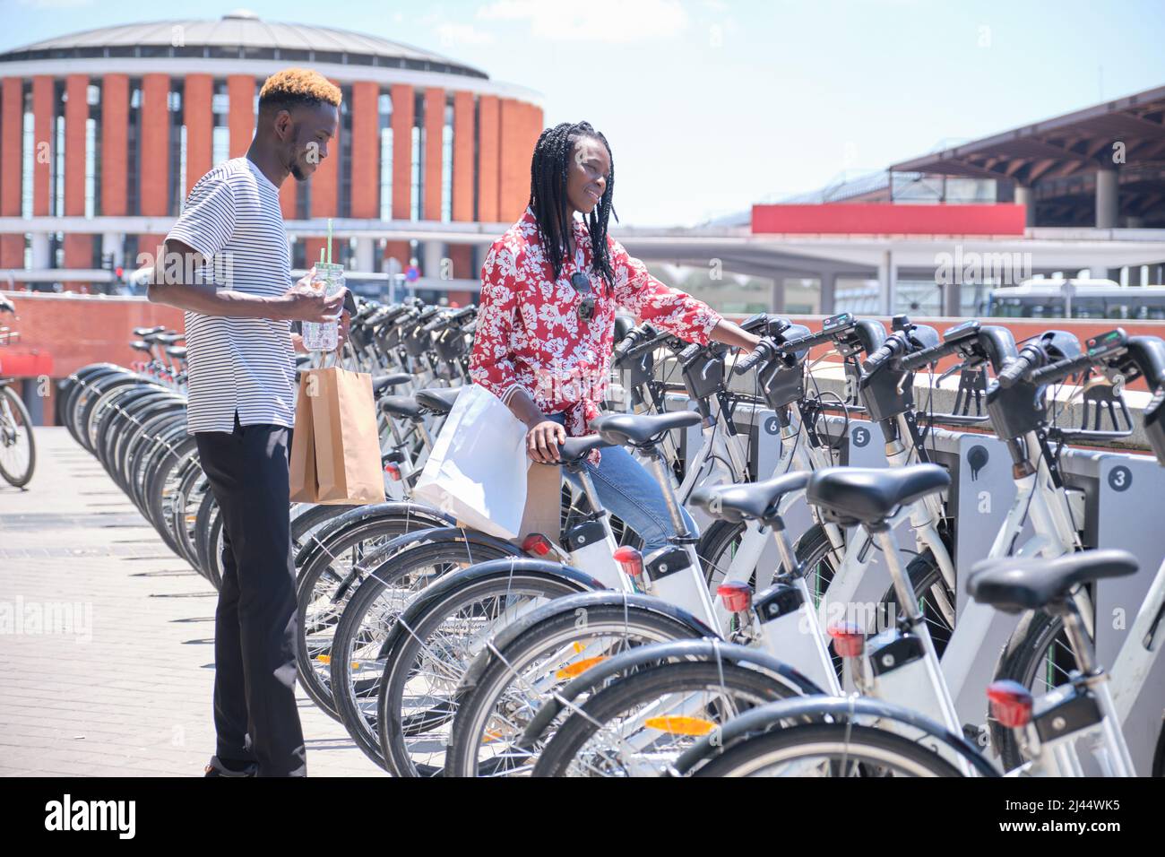 Young african tourists renting a bike at a bicycle rental service ...