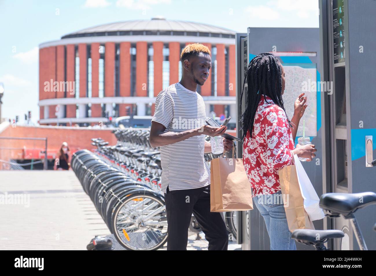 Young african tourists renting a bike at a bicycle rental service ...