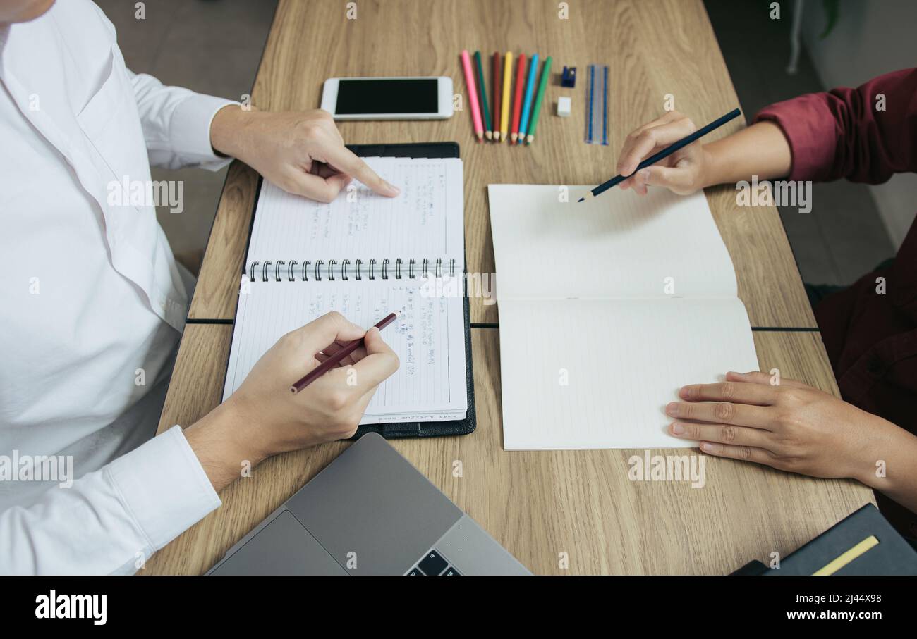 Two student reading textbook for test together in library Stock Photo ...