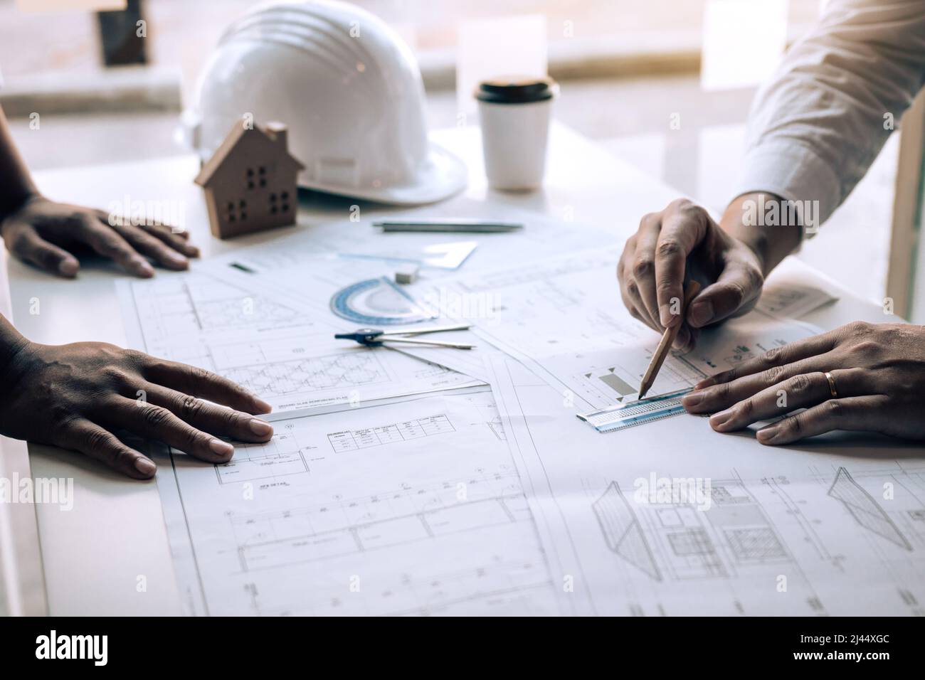Architect working on blueprint discussing new project with colleague in ...