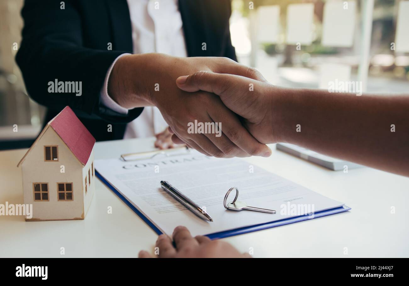 Home sales agents and buyers work on signing new homes and shaking ...