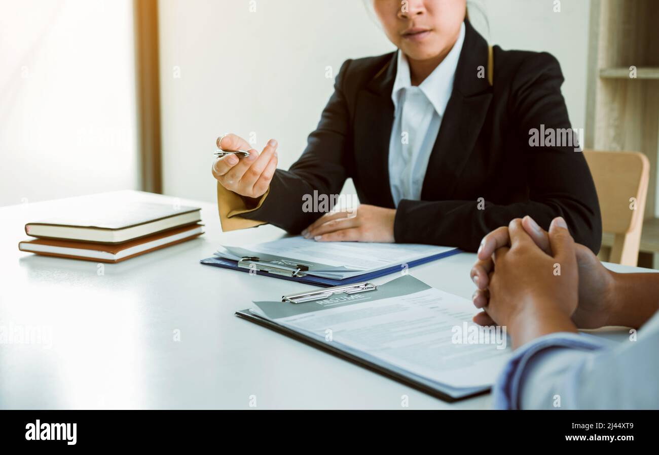 Asian young adult sitting at desk across from manager being interviewed ...