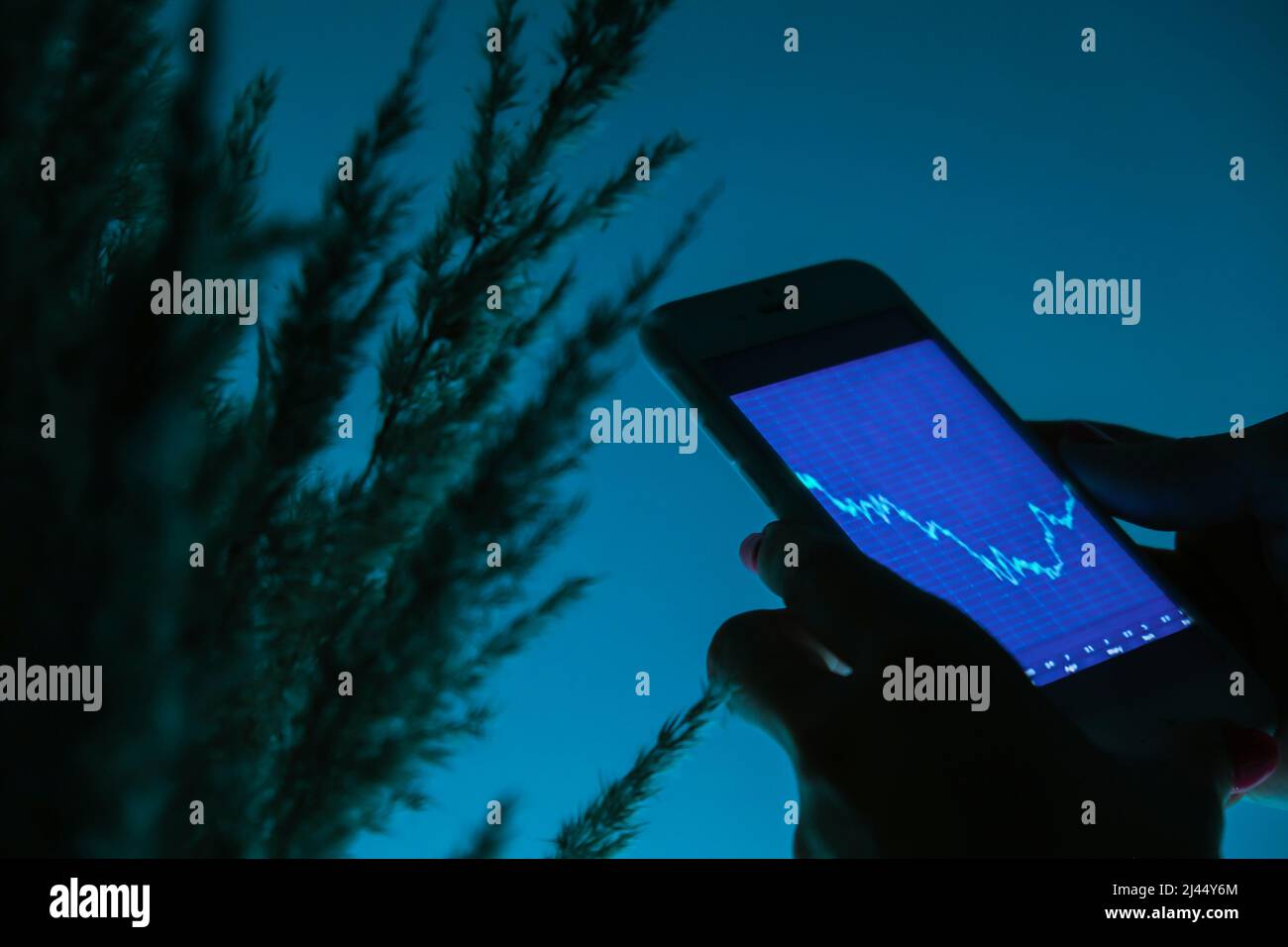 Woman holding mobile phone, block chain with graph of stock market ...