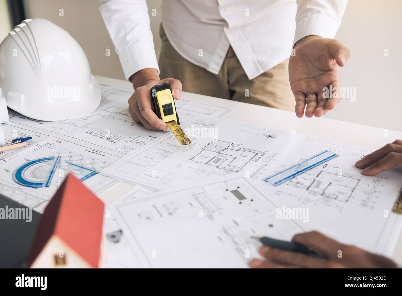 Two partnership architects or engineering working with blueprints and ...