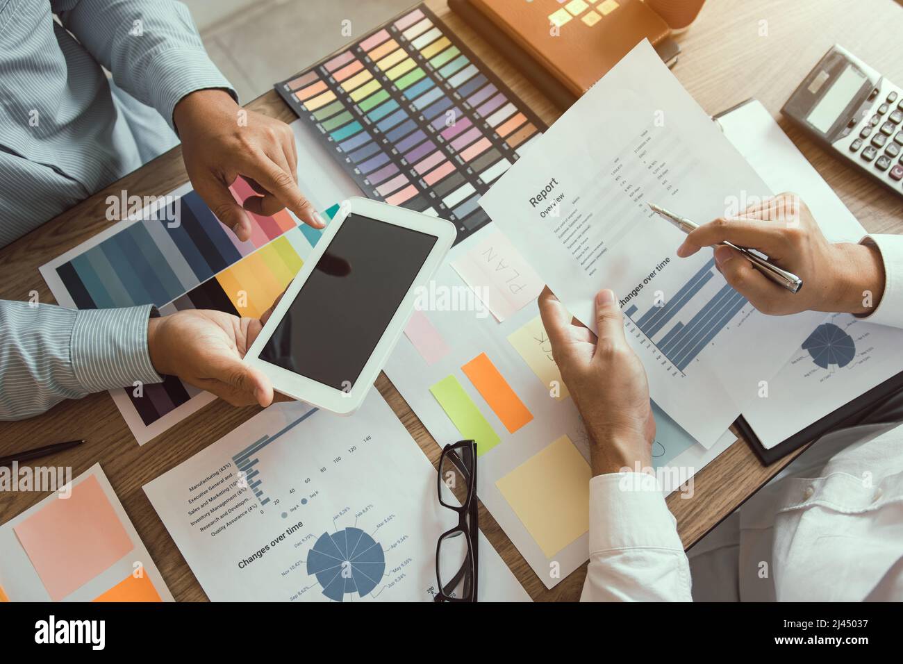 Business partnership coworkers using a tablet to chart company ...