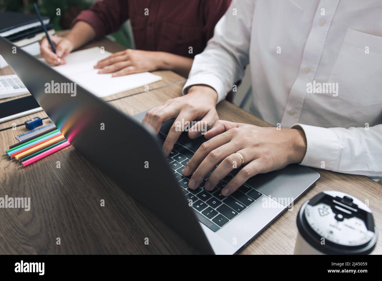 Asian young university students studying together sitting at desk in ...