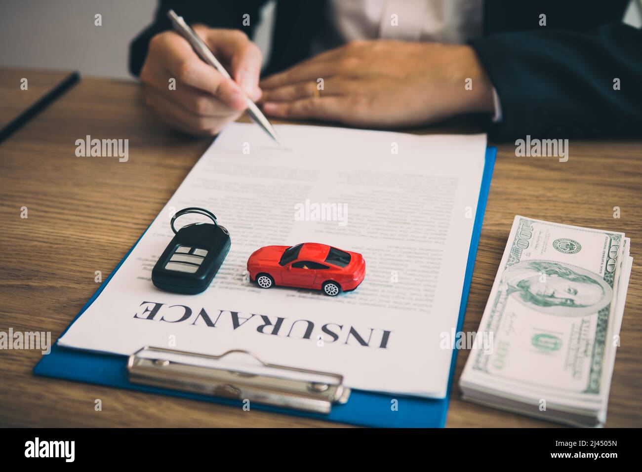 Agent is signing the insurance contract for the car at the document on ...