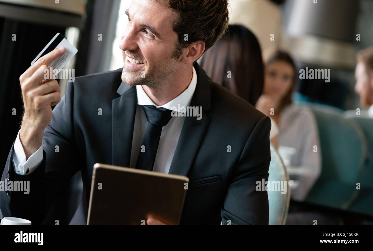 Confident handsome young business man giving payment in cafe Stock ...