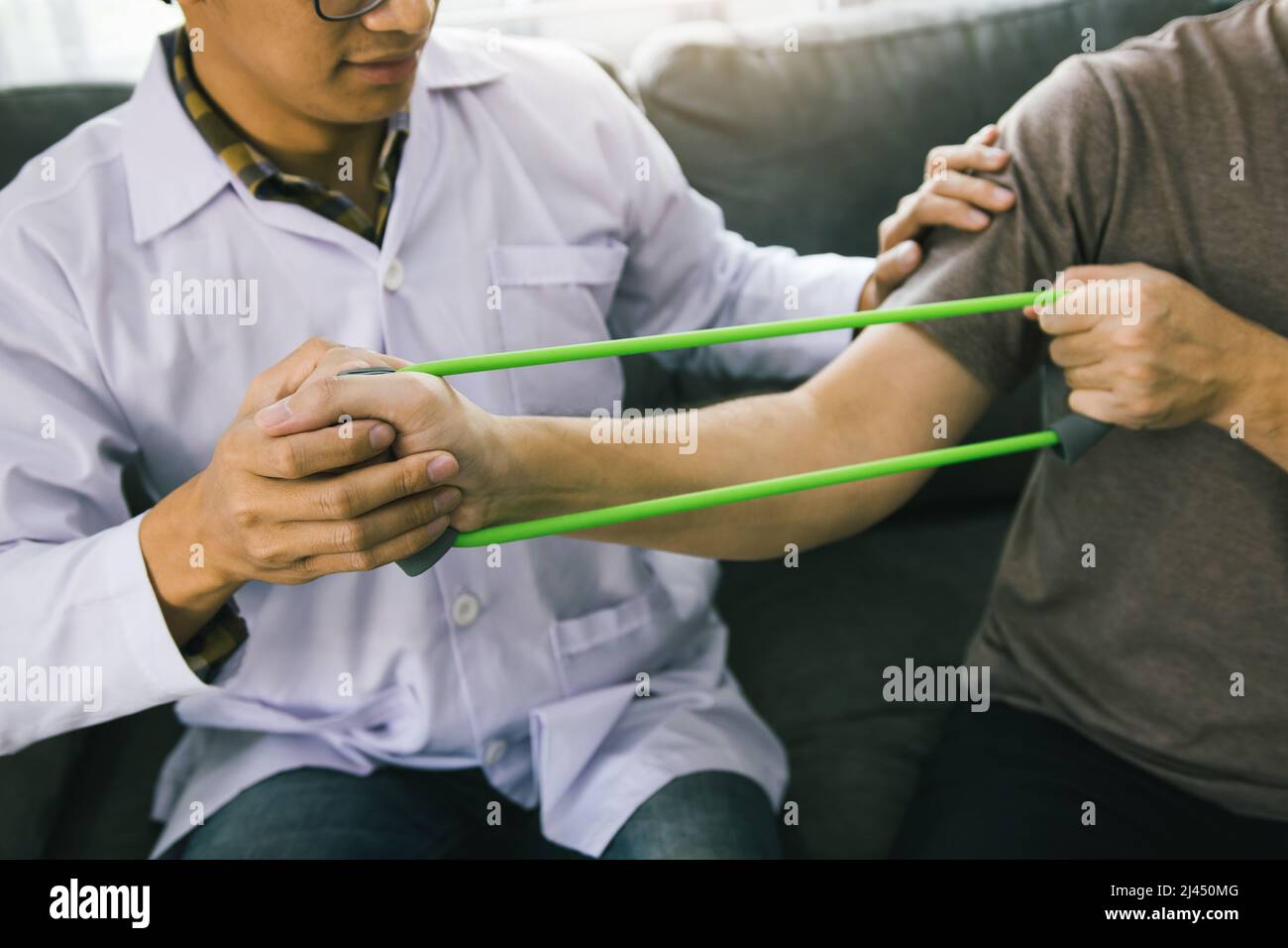 Patient doing stretching exercise with a flexible exercise band and a ...