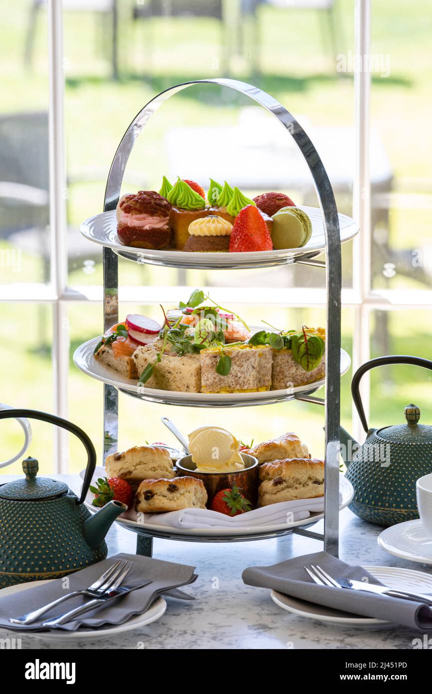 Afternoon tea, sandwiches, cakes, scones and tea served on a cake stand ...