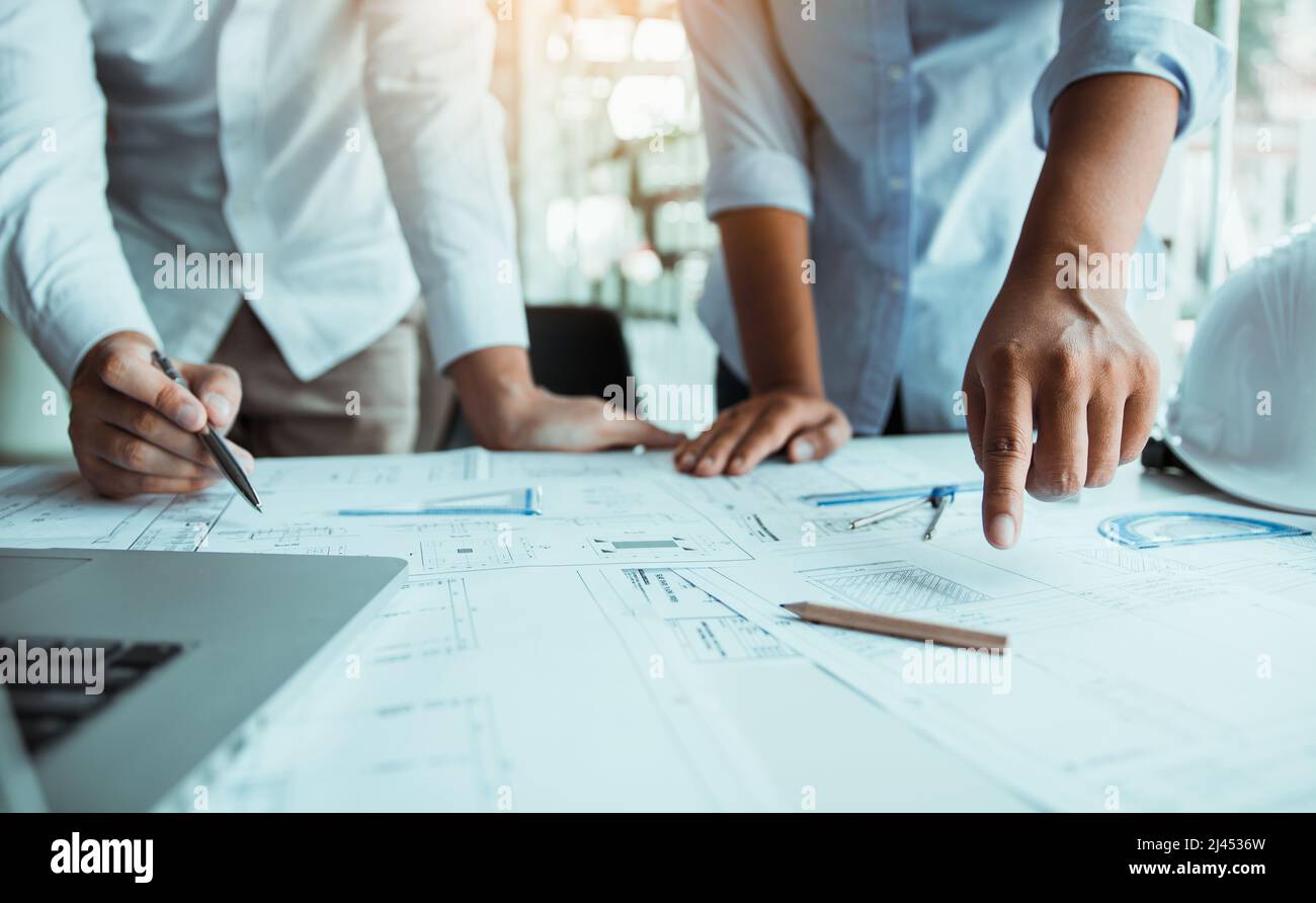Two architect working at construction site and compass drawing pointing ...