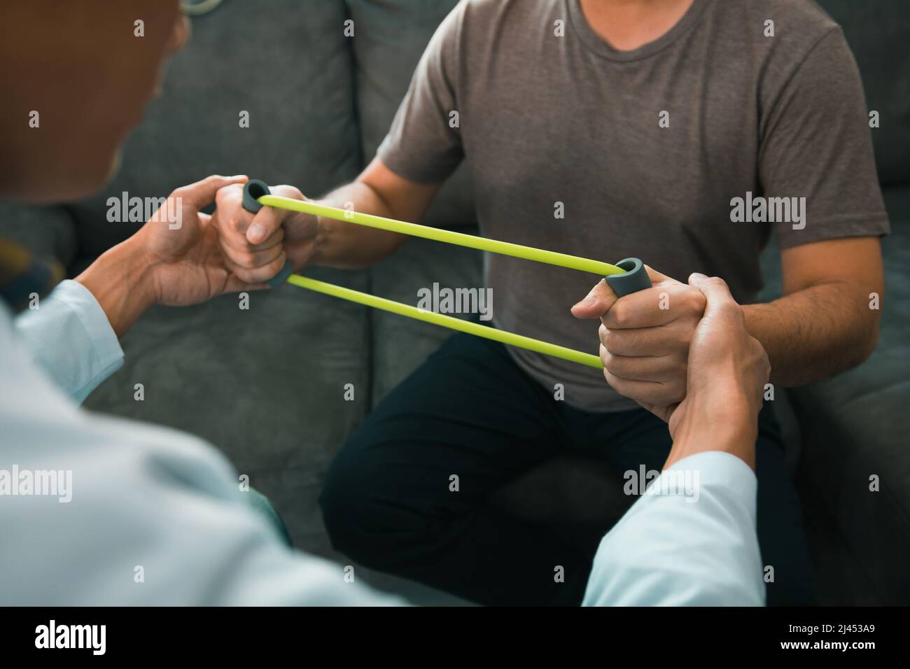 Patient doing stretching exercise with a flexible exercise band and a ...