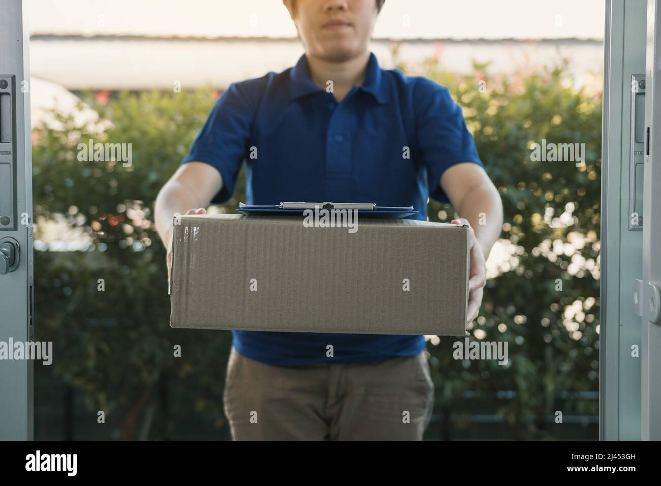 Asian cargo carrier holds a cardboard box with the package inside and ...