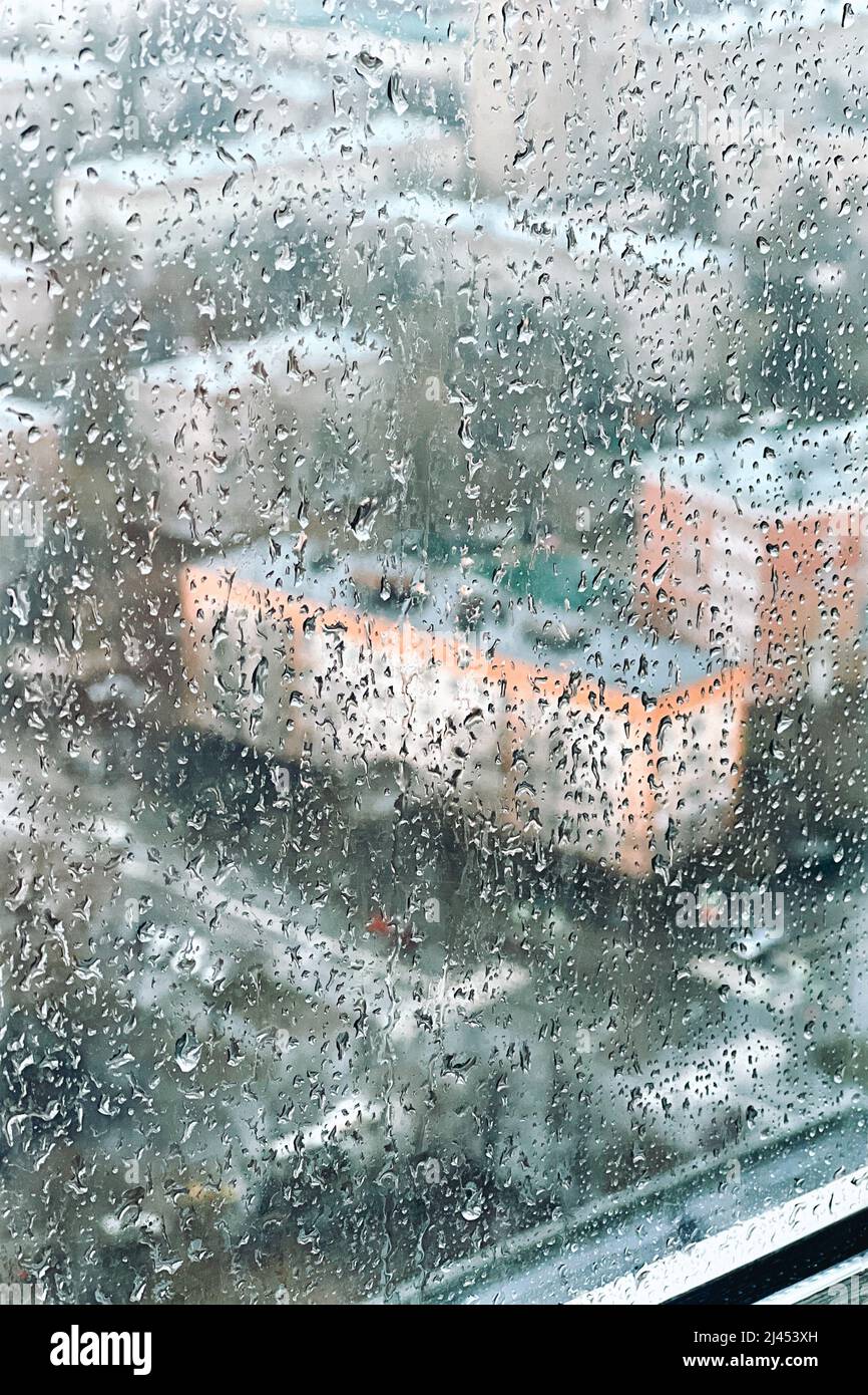 Drops on glass on rainy cloudy day evoke melancholy and sadness. View ...