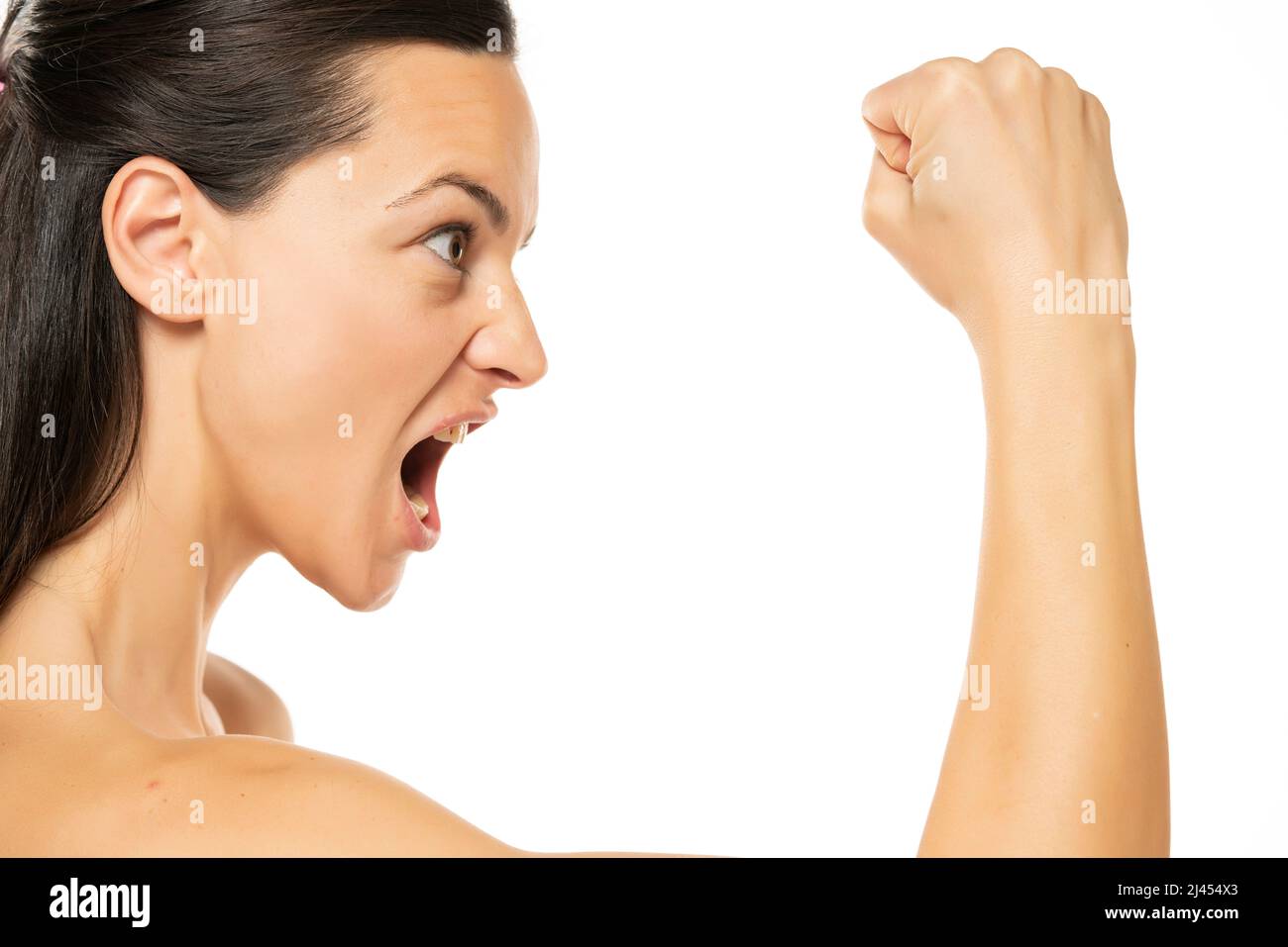 Angry beautiful woman threatening with the fist on a white background ...
