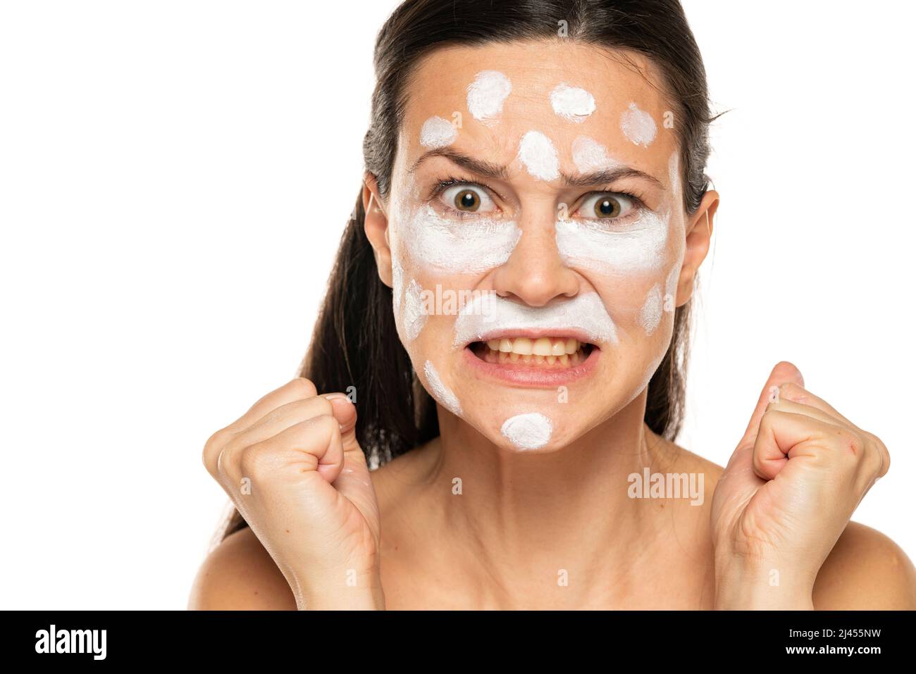 Nervous angry woman posing with face cream on a white background Stock ...