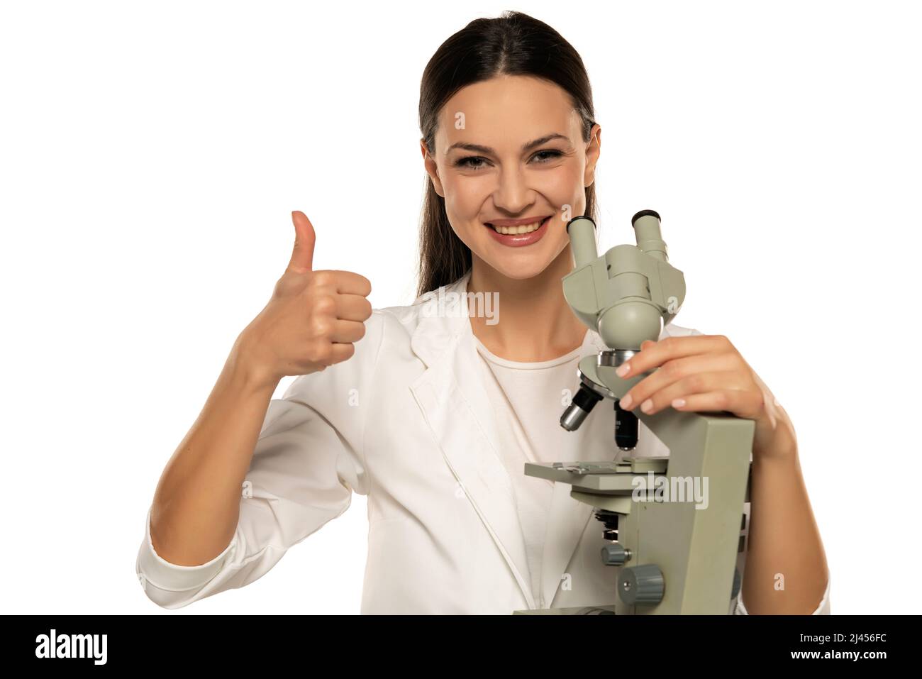 Portrait of female happy scientist with microscope showing thimbs up on ...