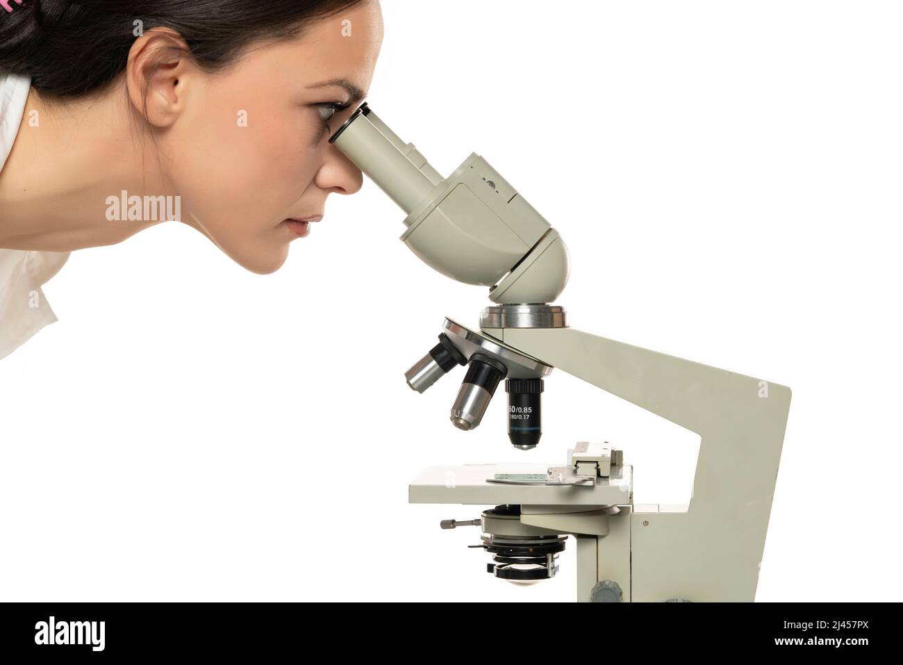 Surprised female scientist looking through a microscope, close up ...