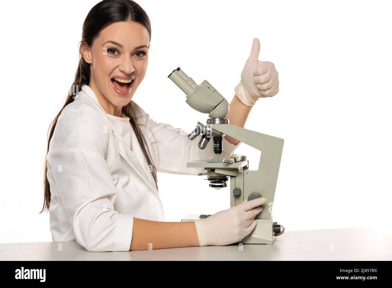 Portrait of happy female scientist with microscope, showing thumbs up ...